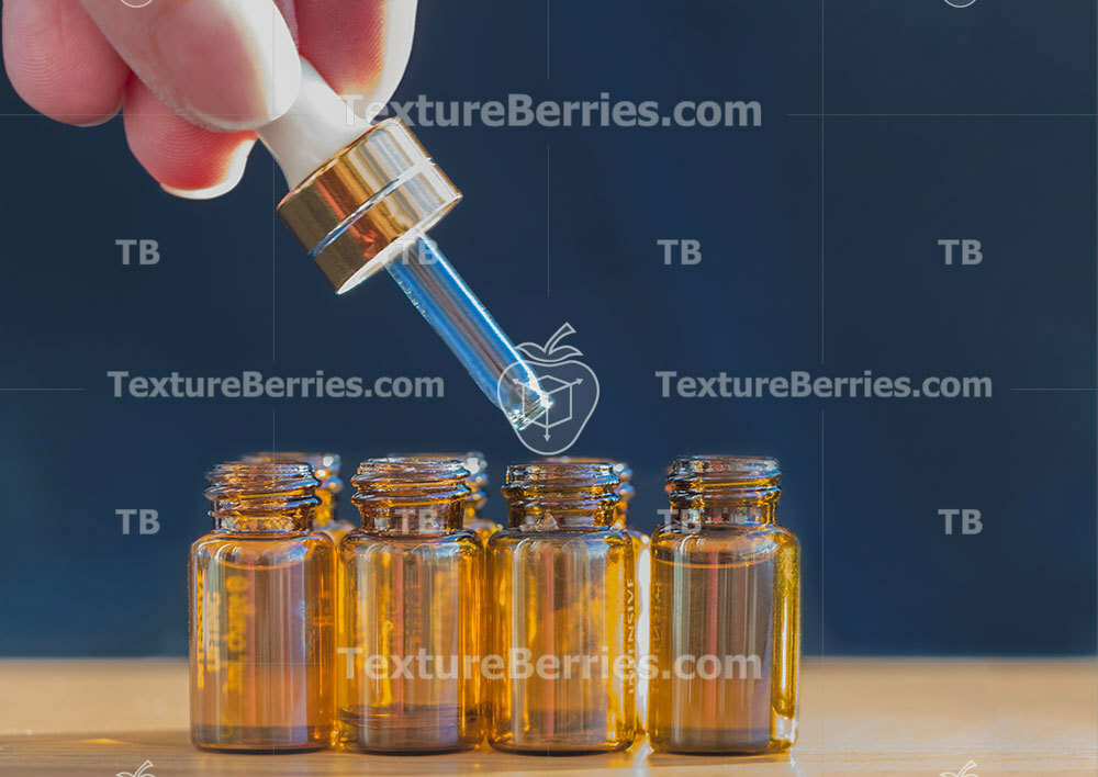 Pipette in hand with small test tubes on dark blue background