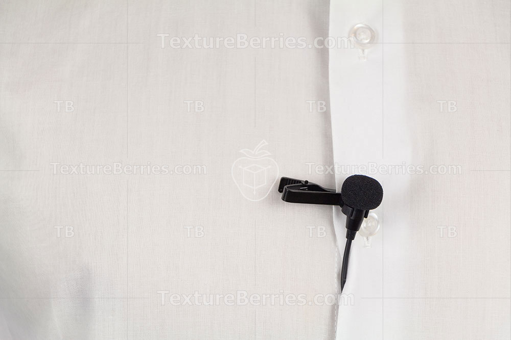 Black lavalier microphone on white man's shirt